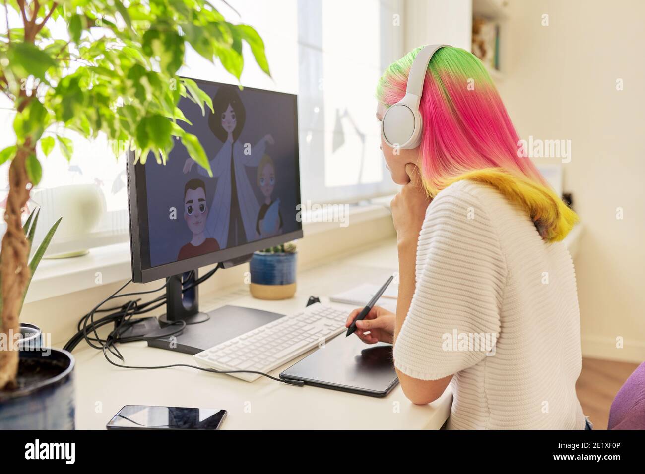 Girl teenager artist in headphones drawing on computer using graphics ...