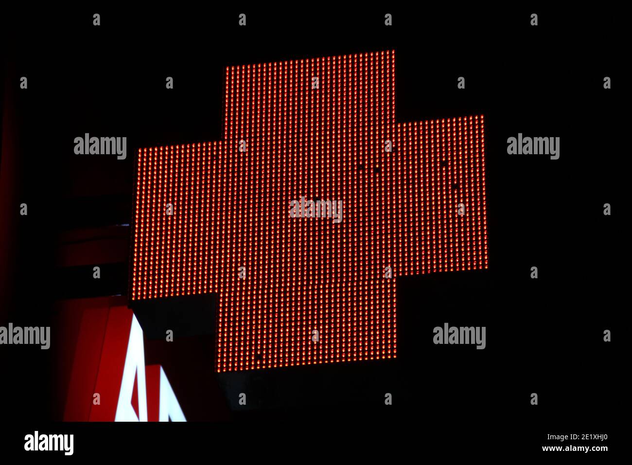Glowing pixel cross of LED lamps on black background. Red cross symbol ...