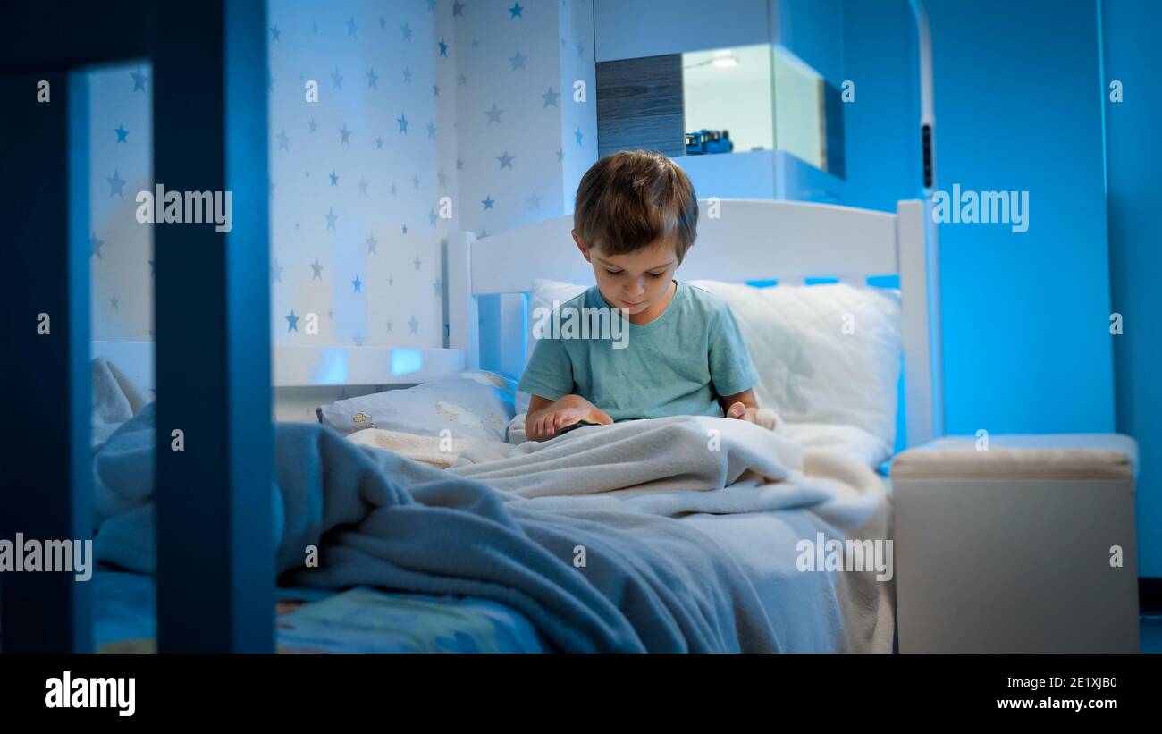 Little 5 years old boy using and playing on tablet computer before ...