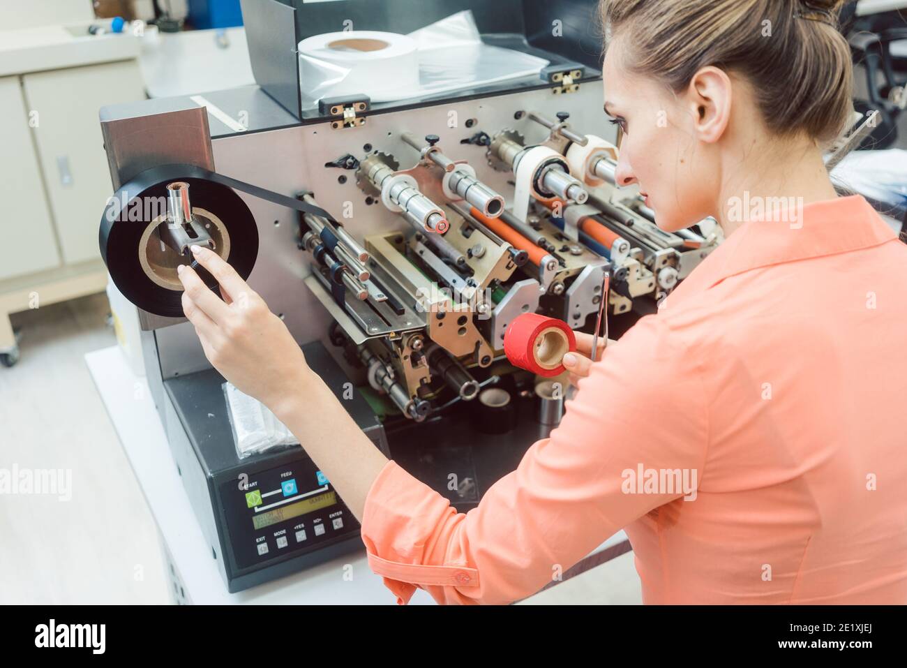 Worker woman putting new labels in printing machine Stock Photo - Alamy