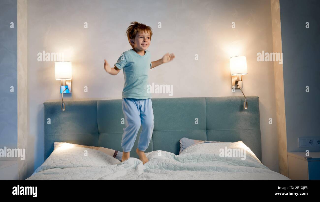 Happy laughing and smiling toddler boy in pajamas skipping and jumping ...