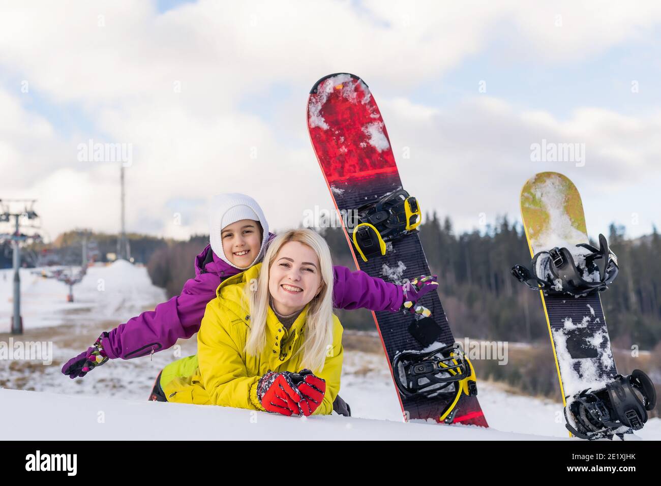mother and daughter with snowboards in a mountain resort Stock Photo ...