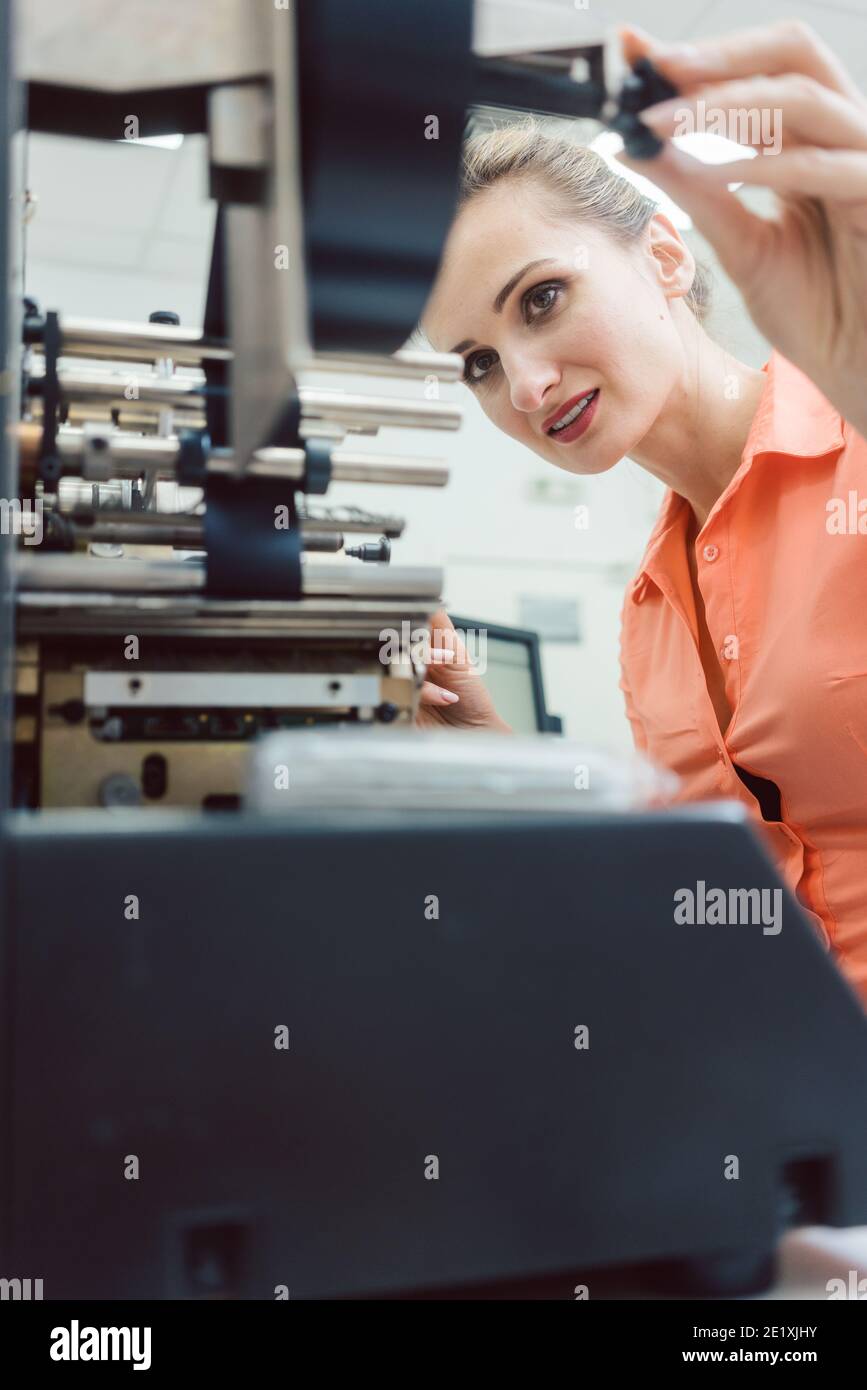 Worker woman putting new labels in printing machine Stock Photo - Alamy