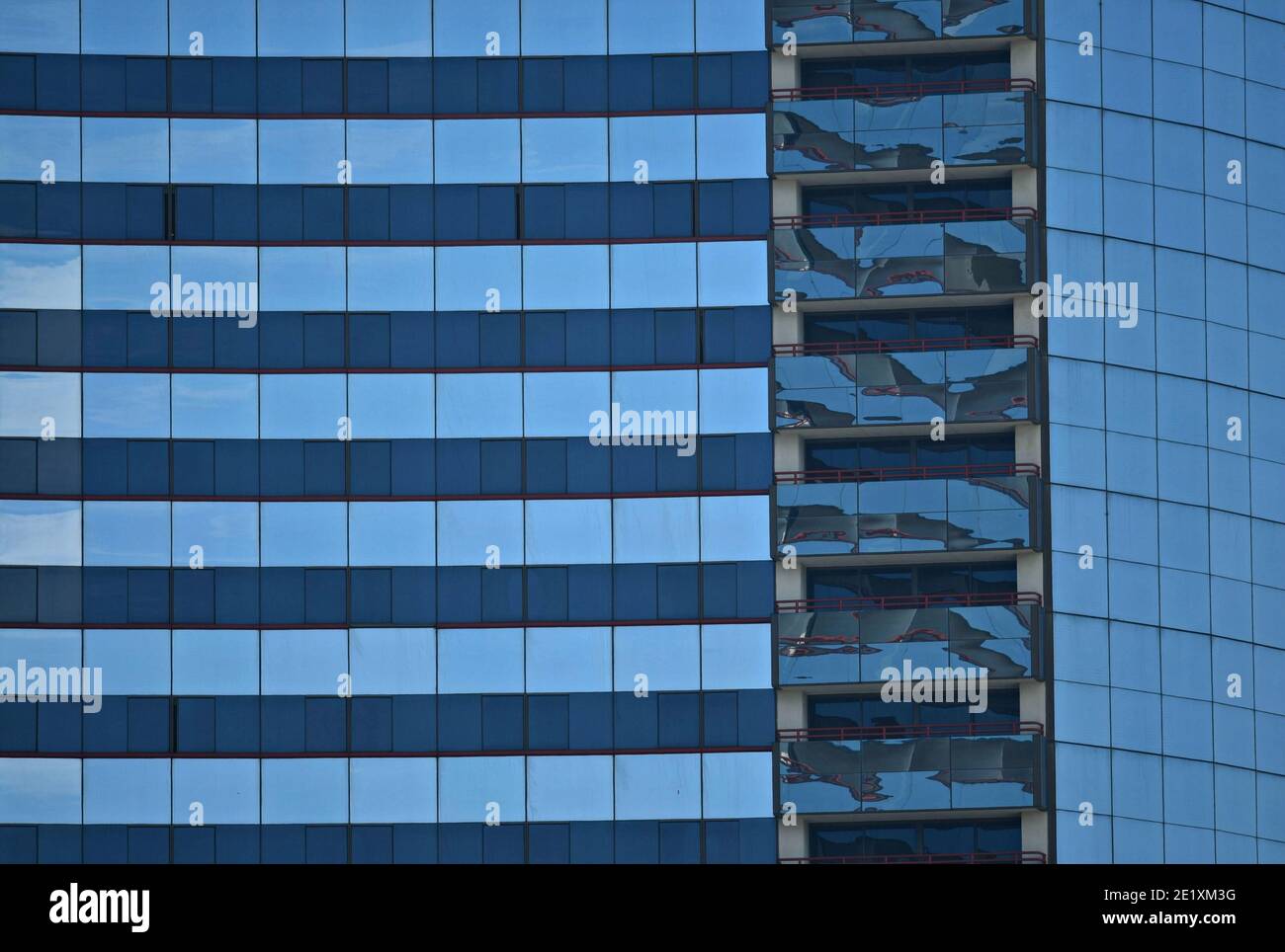 Urban high-rise blue glass facade with symmetrical balconies in ...