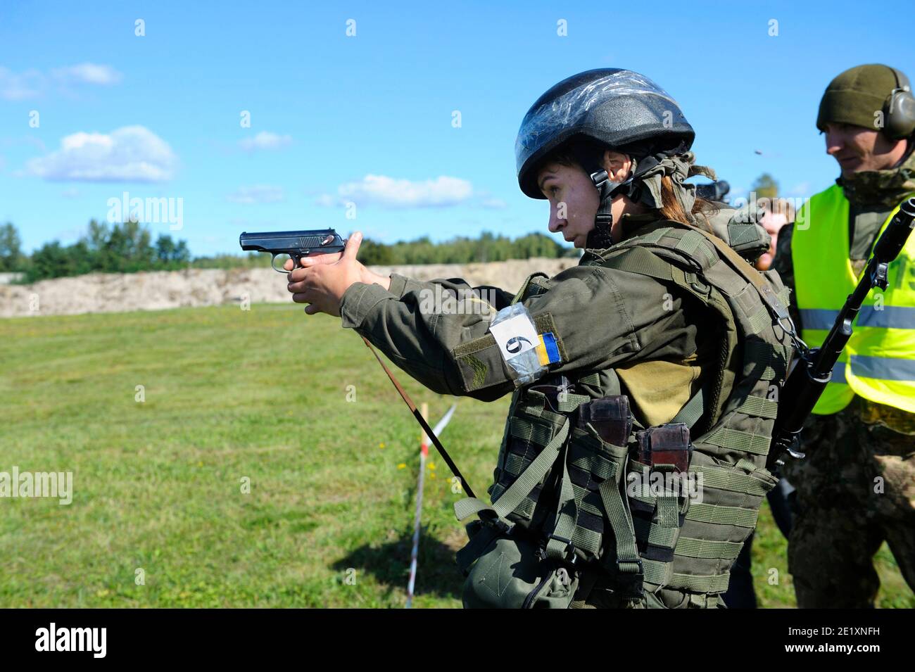 On a military shooting range: fully equipped female soldier aiming at ...