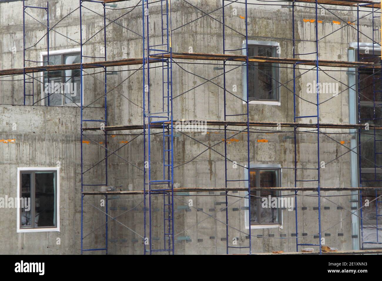 Scaffolding near the concrete wall of a building under construction ...