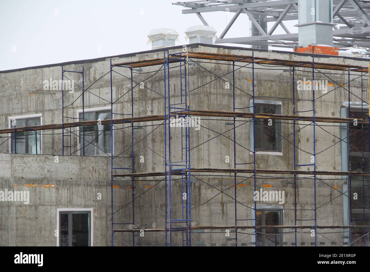Scaffolding near the concrete wall of a building under construction ...