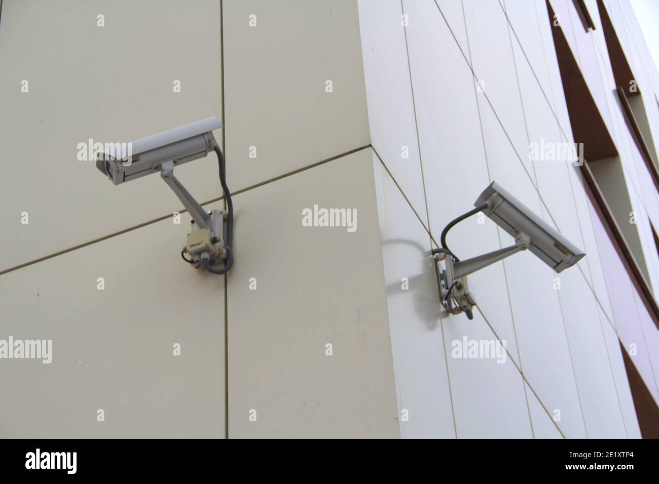Surveillance camera mounted on tiled wall of house. Security concept ...