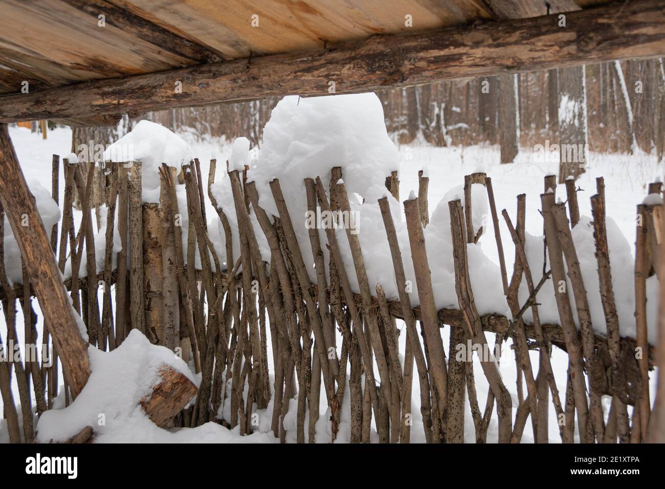 Old wooden village fence made of branches under snow Stock Photo - Alamy