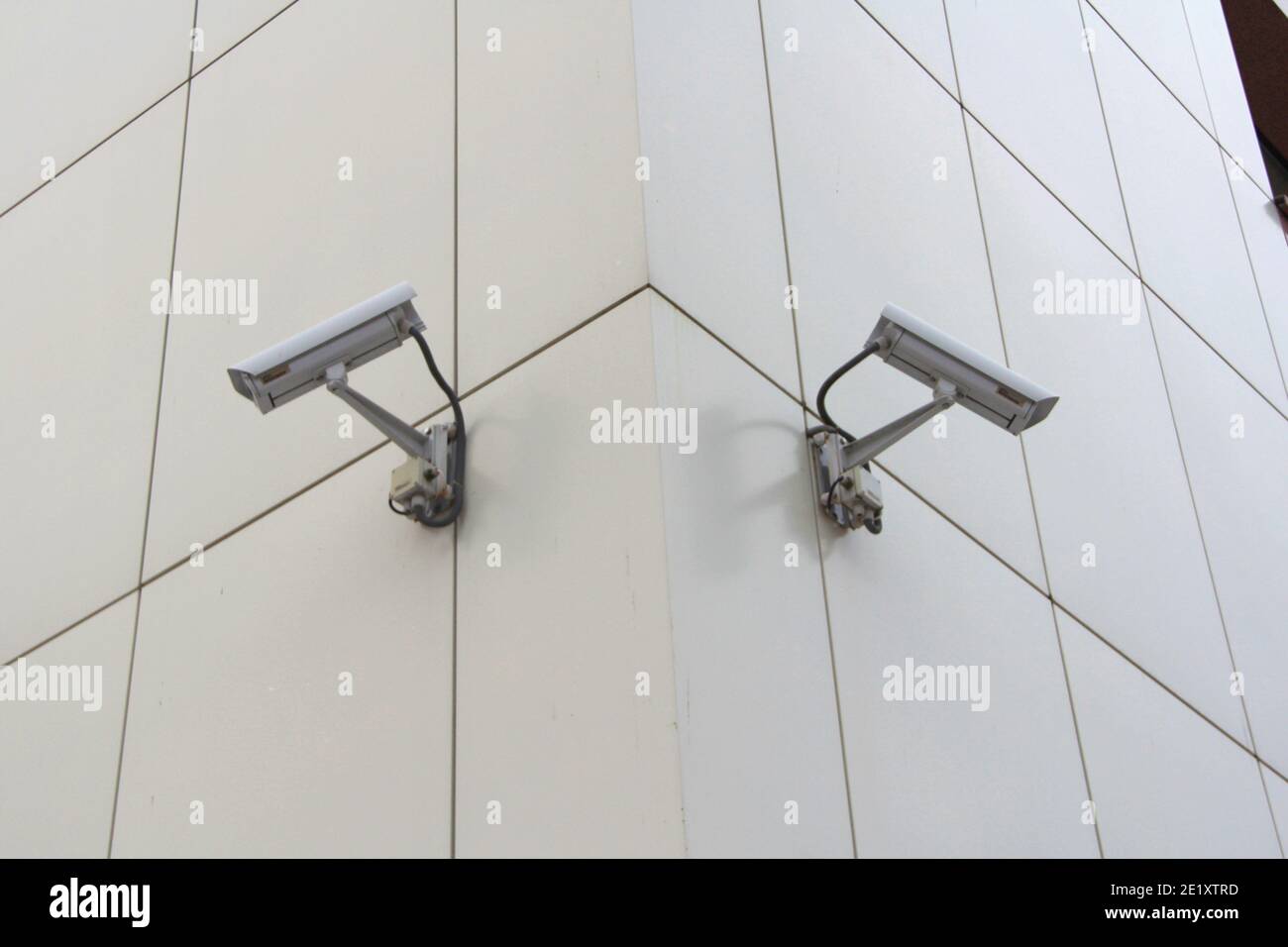 Surveillance camera mounted on tiled wall of house. Security concept ...