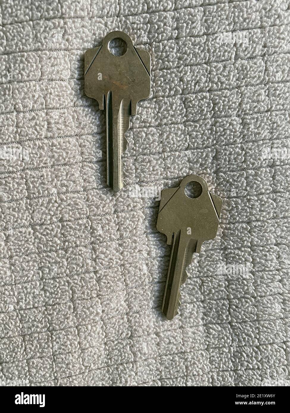Two keys used for unlocking a door lying on soft blanket Stock Photo ...