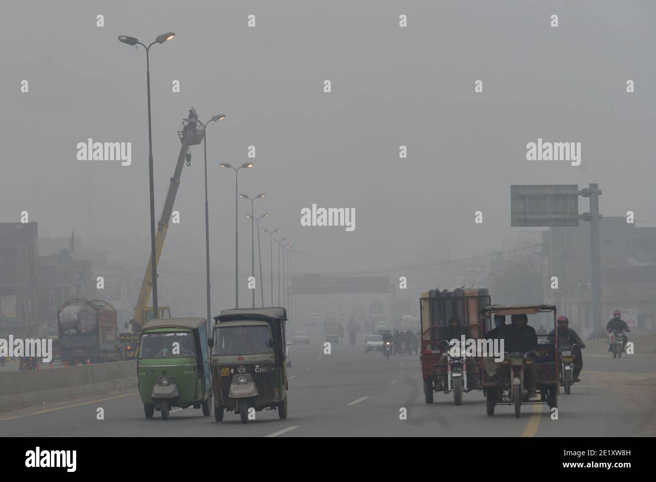 Pakistani Commuters make their way amid dense fog on a cold winter ...