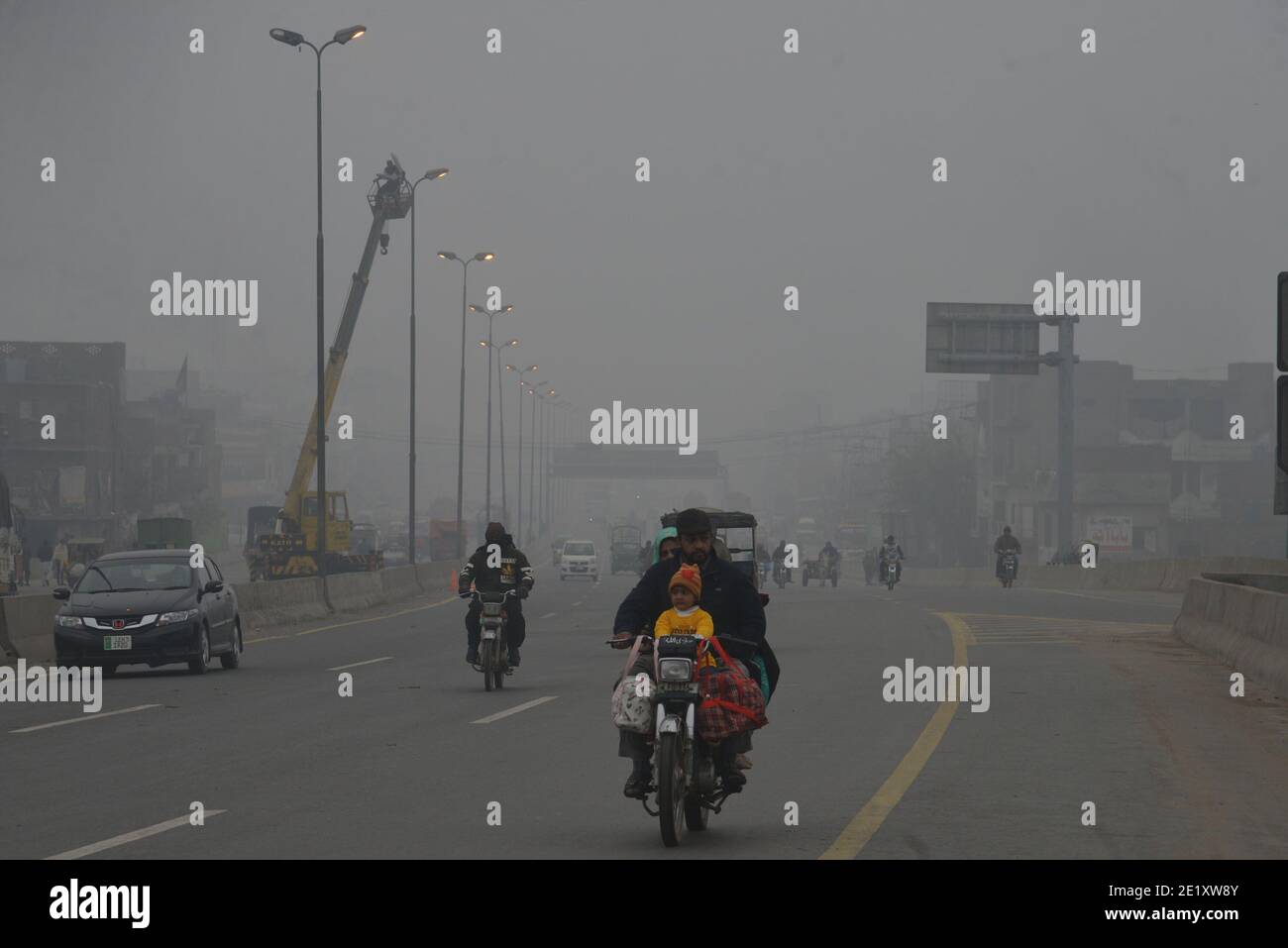 Pakistani Commuters make their way amid dense fog on a cold winter ...