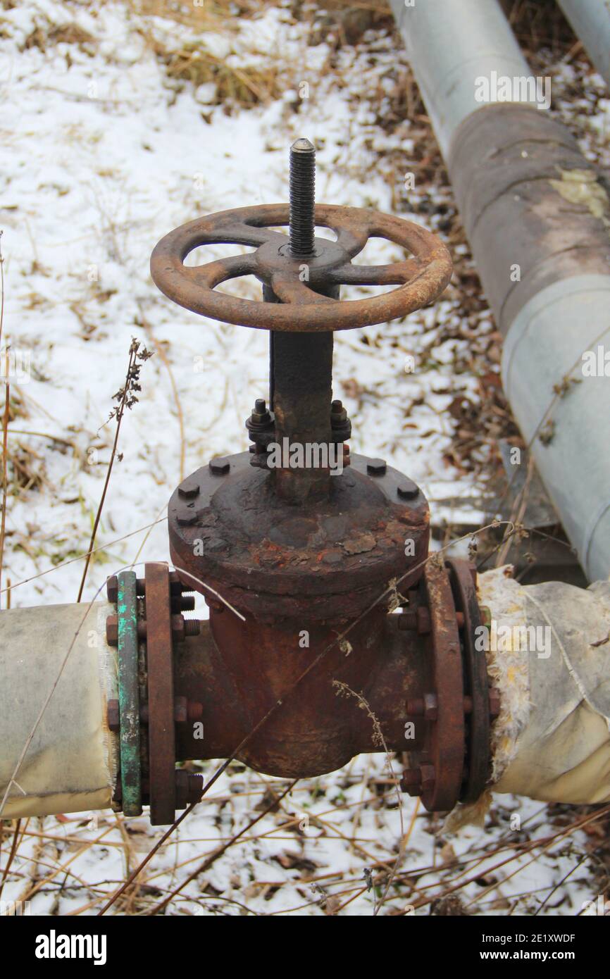Old damaged and rusty iron oil pipe valve wheel. Metal, pipeline and ...