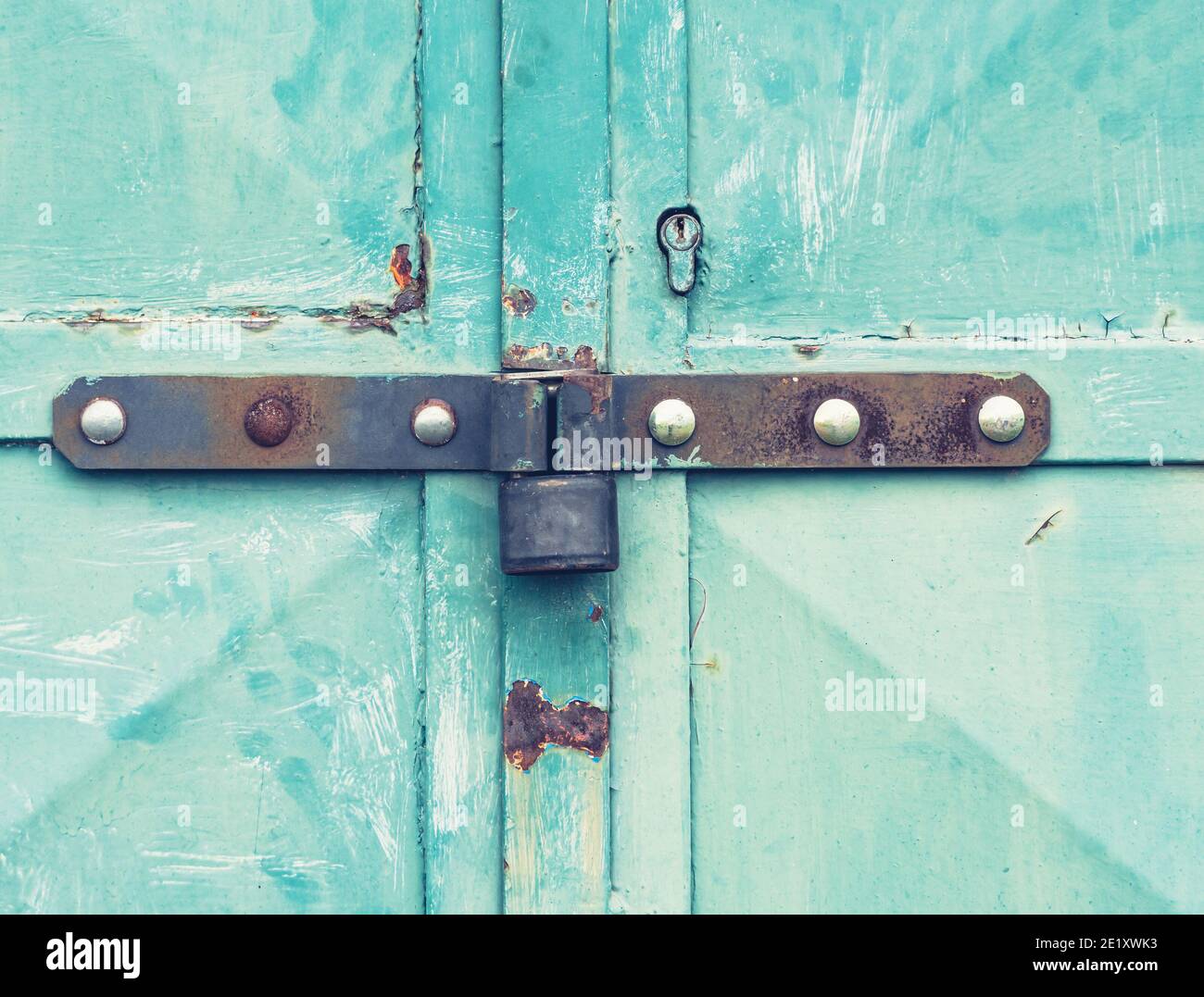 Old rusty lock latch on the metal door. Obsolete cracked painted ...