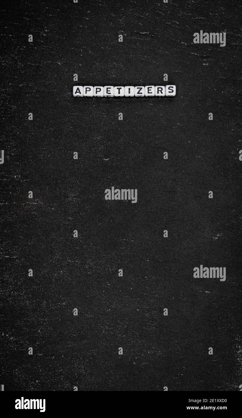 Word appetizers on black stone background Stock Photo - Alamy