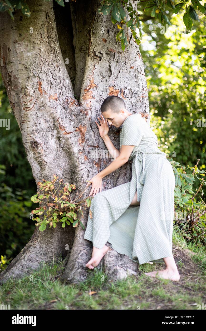 Non-binary shaved head biological female in green dress connecting with ...