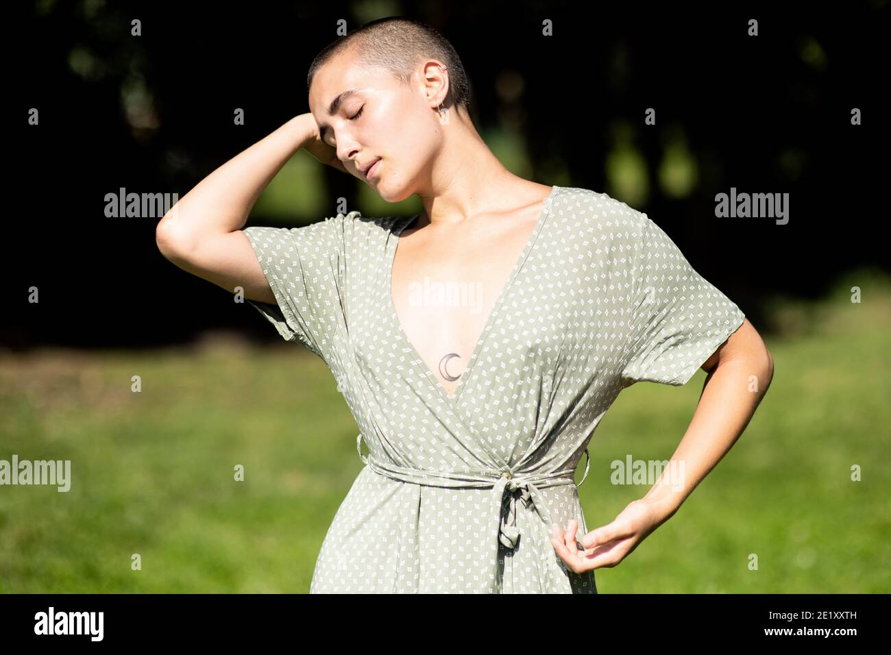 Non-binary shaved head biological female in green dress connecting with ...