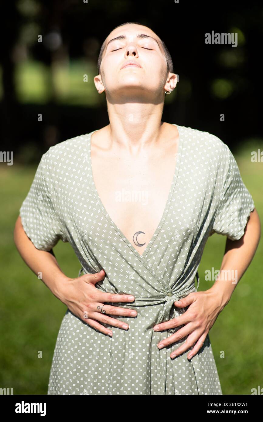 Non-binary shaved head biological female in green dress connecting with ...