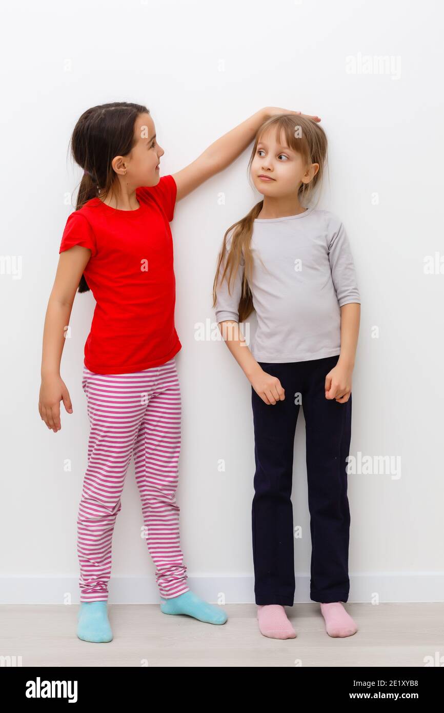 Two cute little girls in full growth, in the studio on a white ...