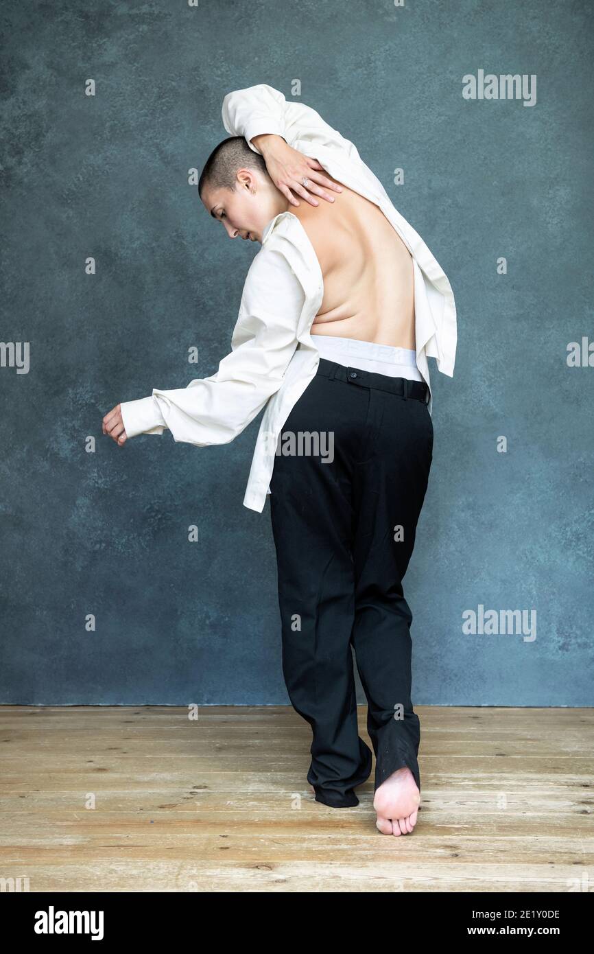 shaved head female who identifies as non-binary in white mens shirt and ...