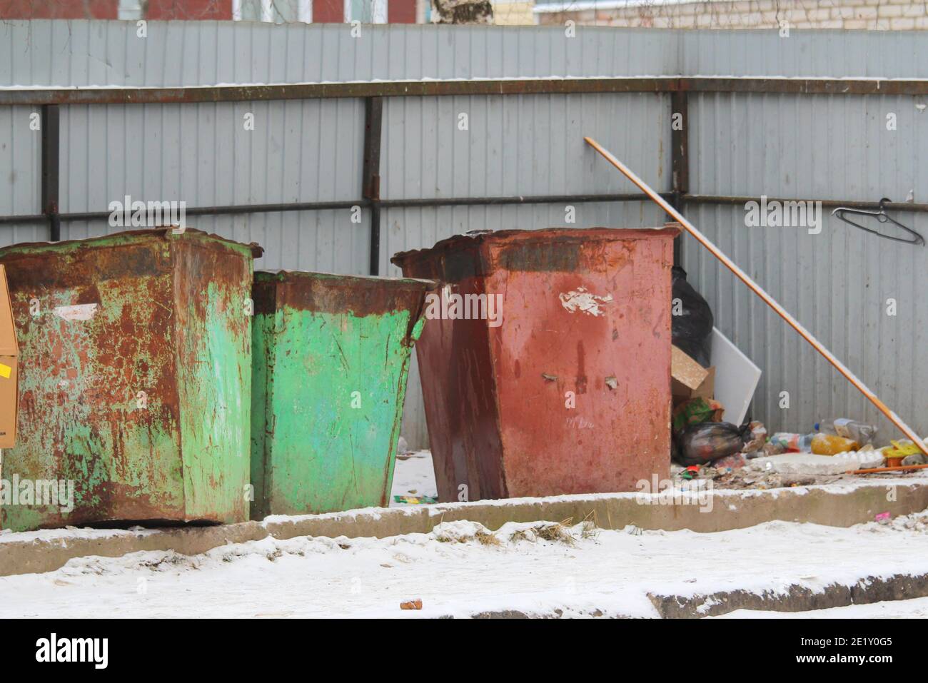 Old rusty street garbage containers of green and red colors. Waste ...