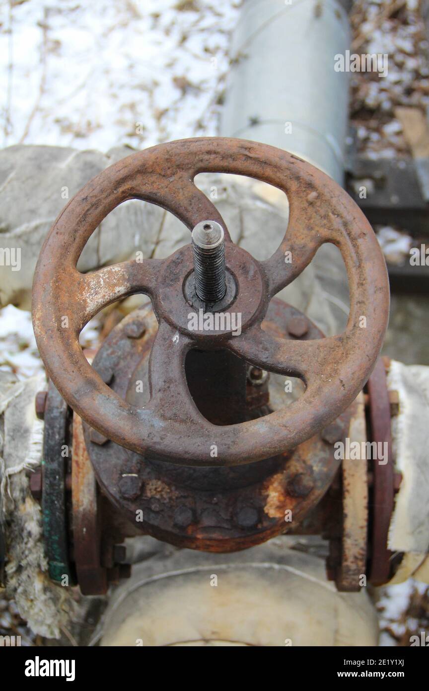 Old damaged and rusty iron oil pipe valve wheel. Metal, pipeline and ...