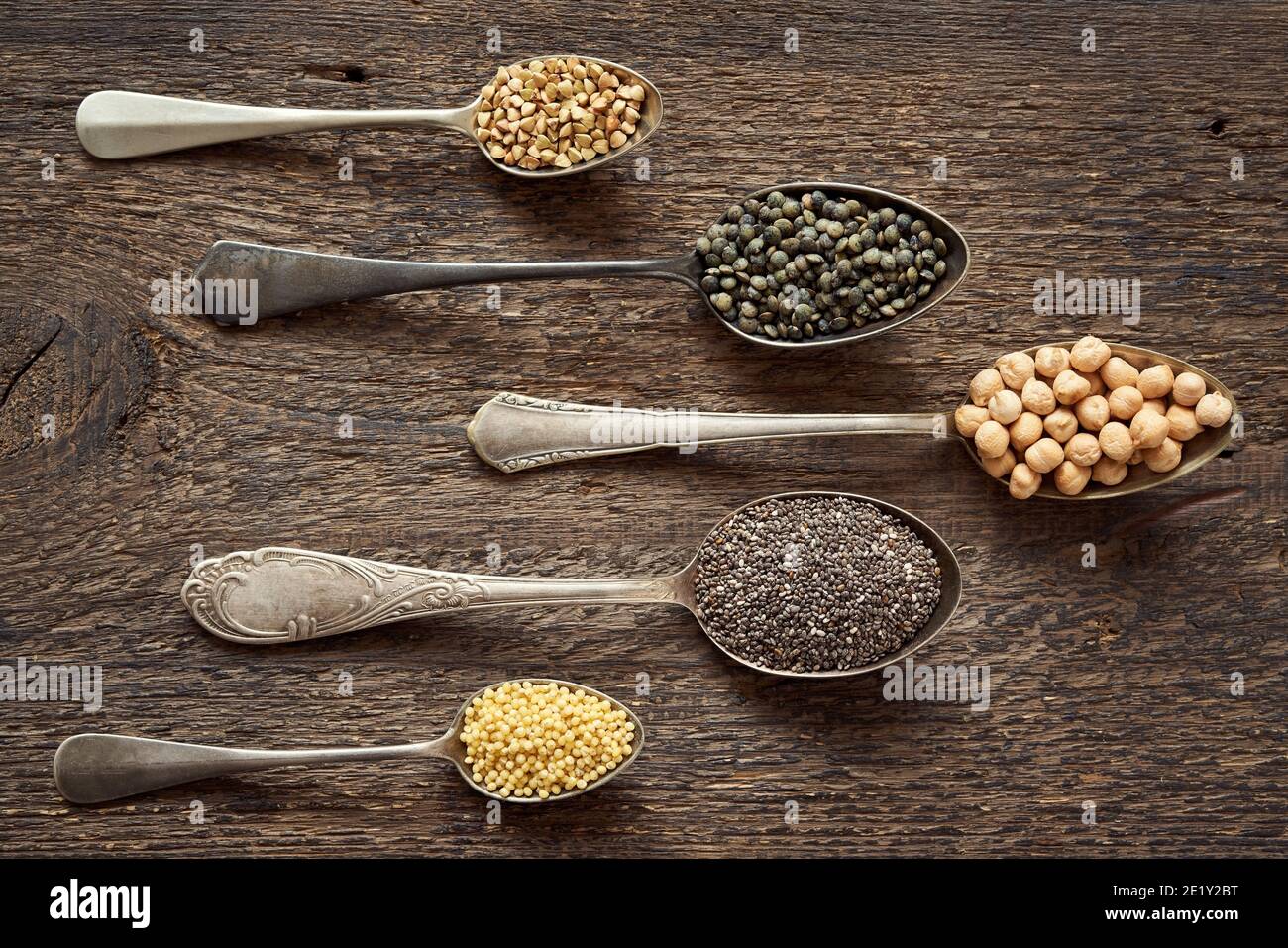 Millet, chia, chickpeas, buckwheat and lentils on five vintage spoons ...