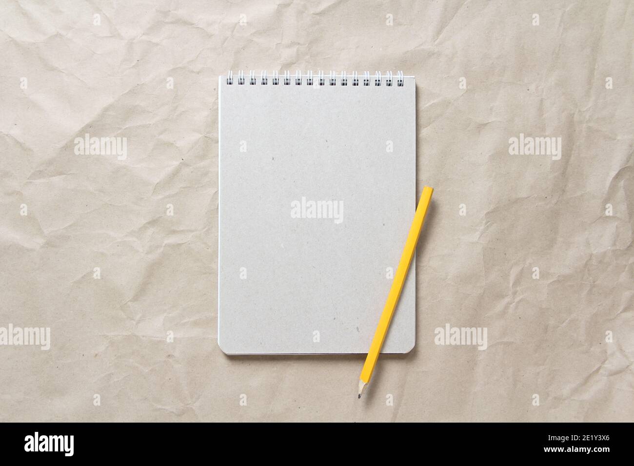 Gray notepad with white coiled spring and pencil on a background of ...