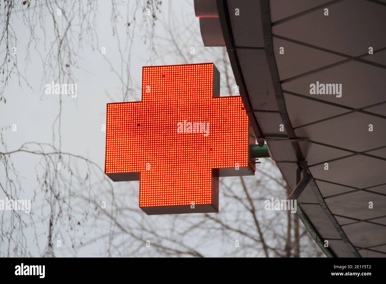 Red LED cross on outdoors, symbol of health and pharmacy products ...