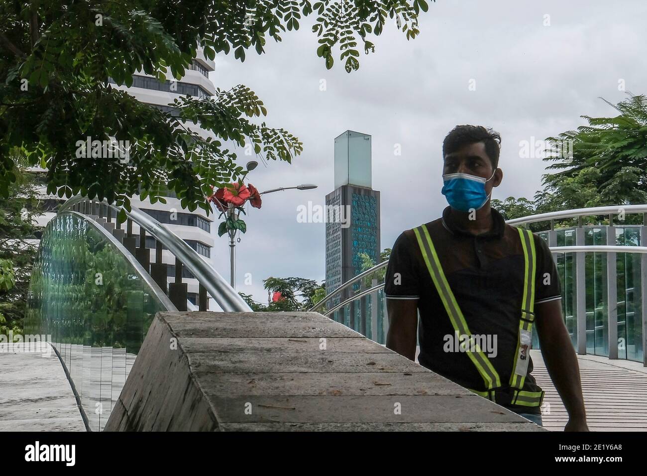 A worker wearing a face mask as a precaution against the spread of ...