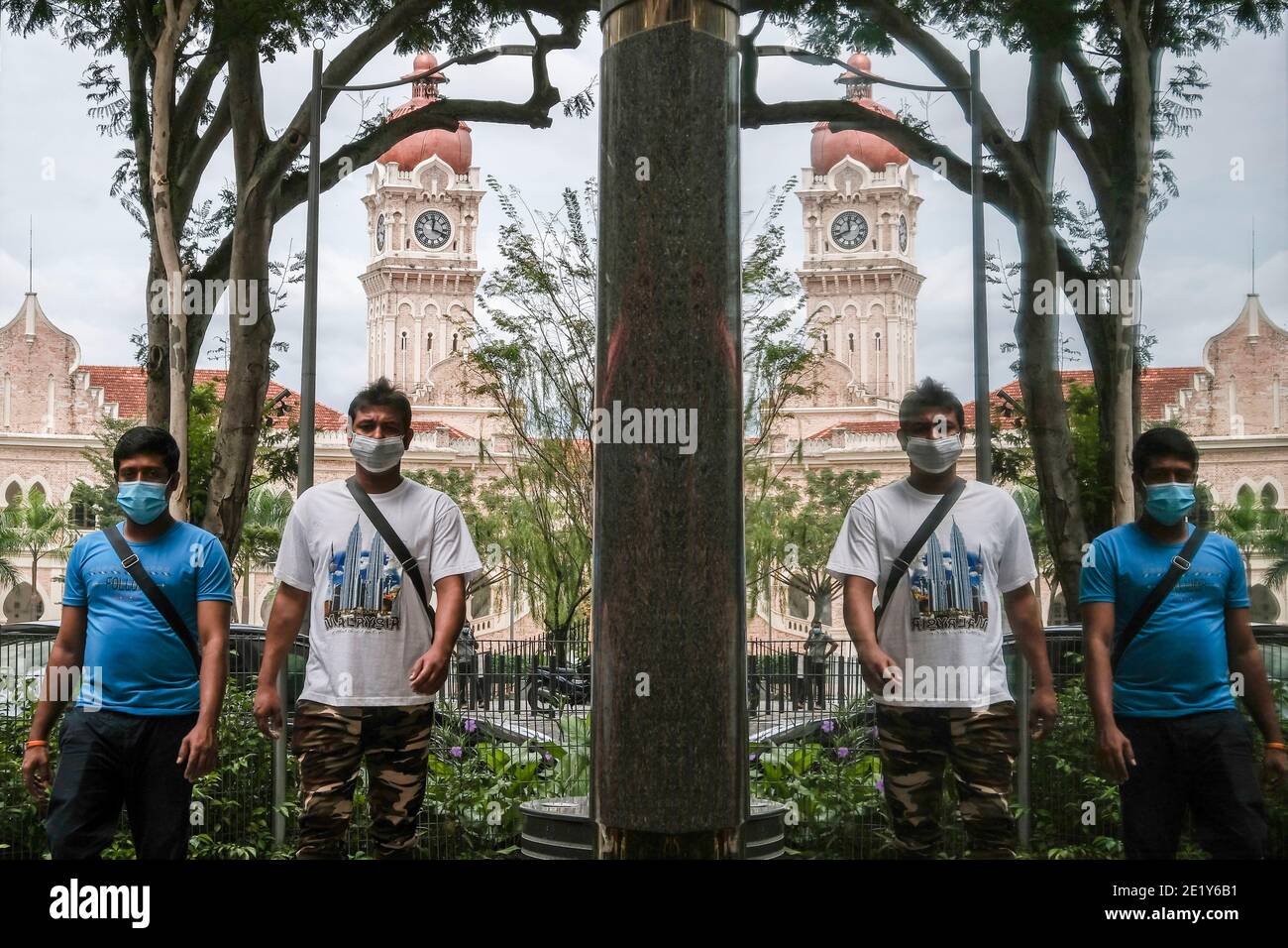 Reflection of men wearing face masks as a precaution against the spread ...