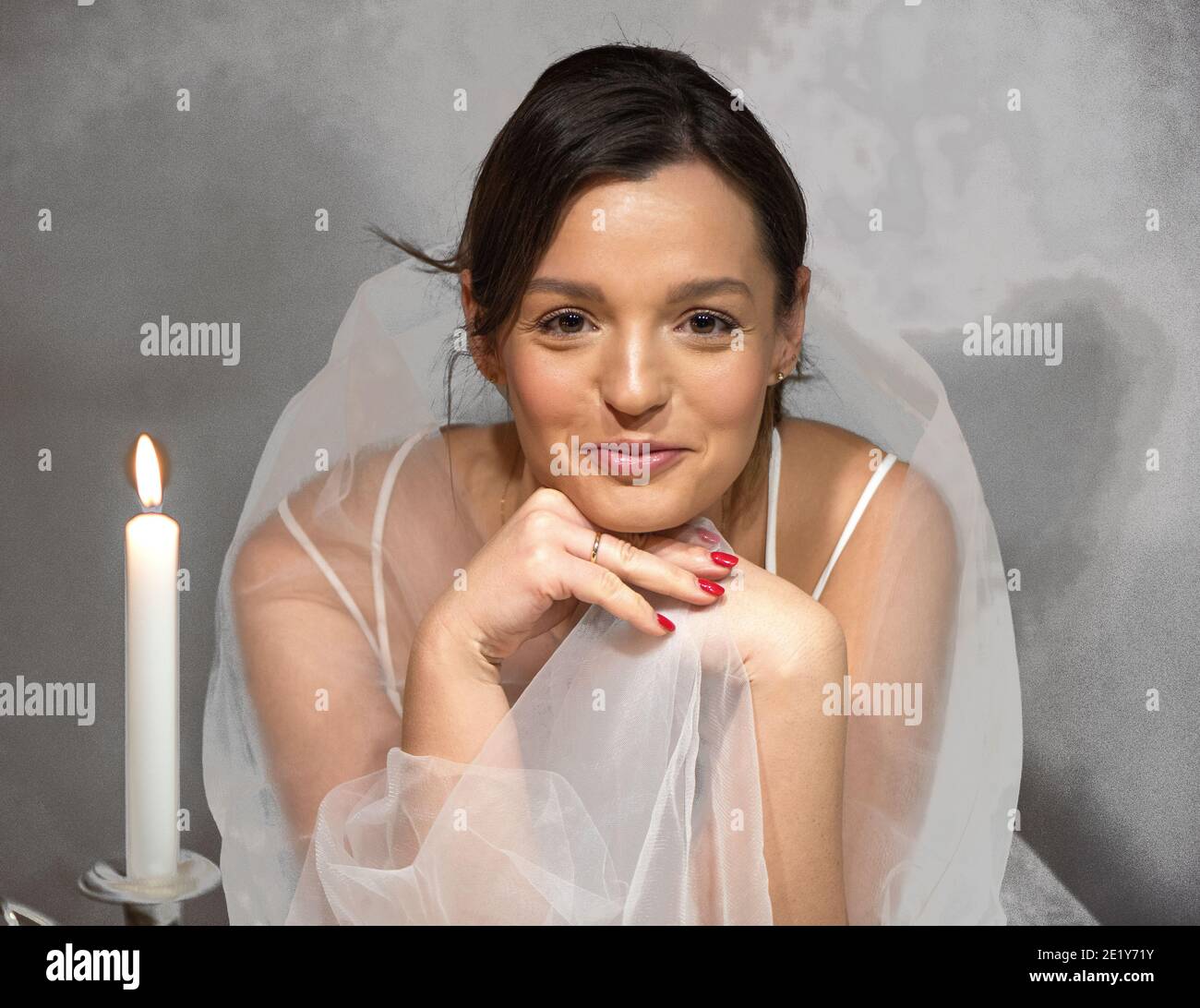 Elegant Woman in Candlelight, Draped in a Soft White Veil, Radiating ...