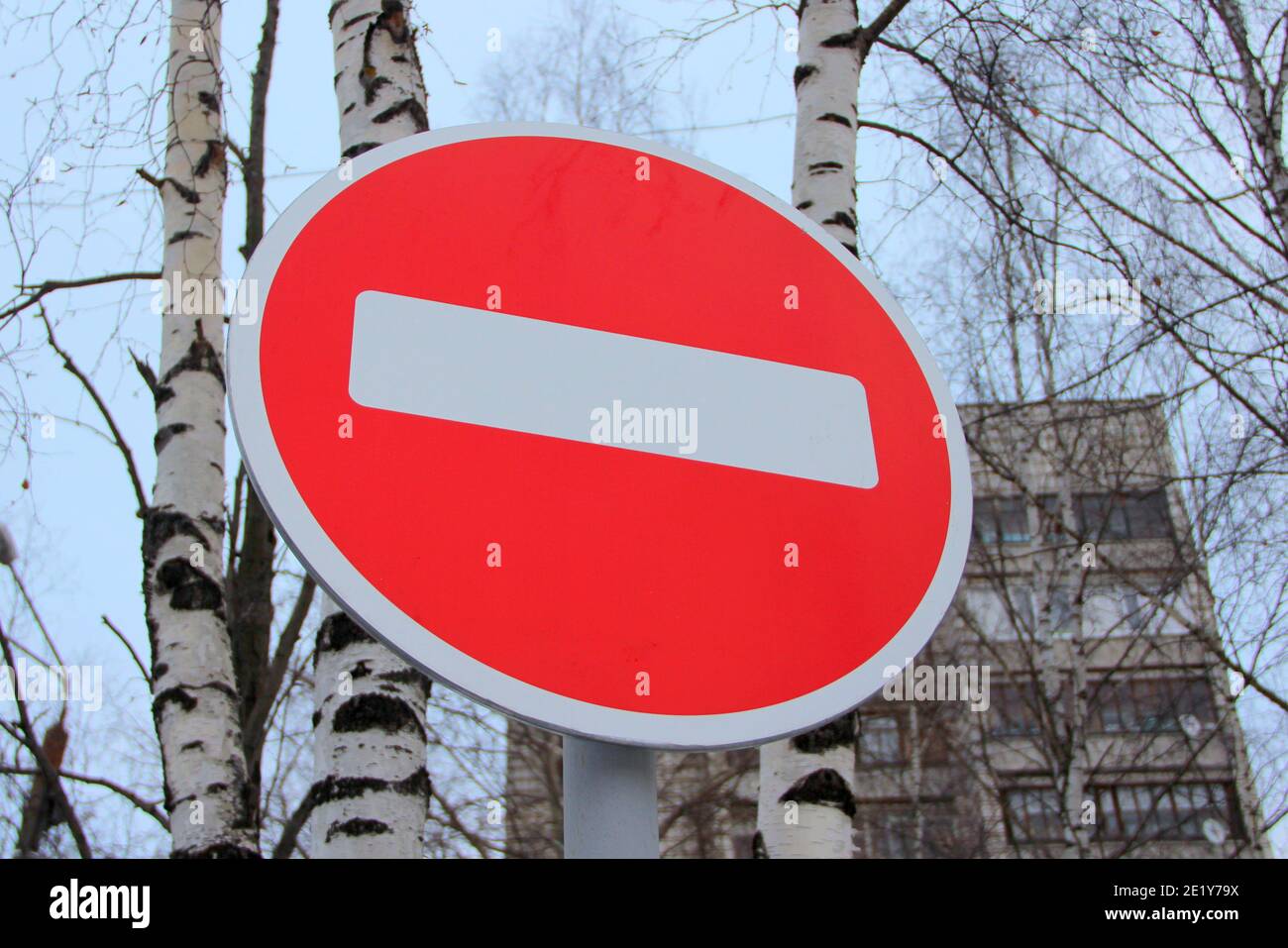 Red round road sign with white stripe prohibiting movement against the ...