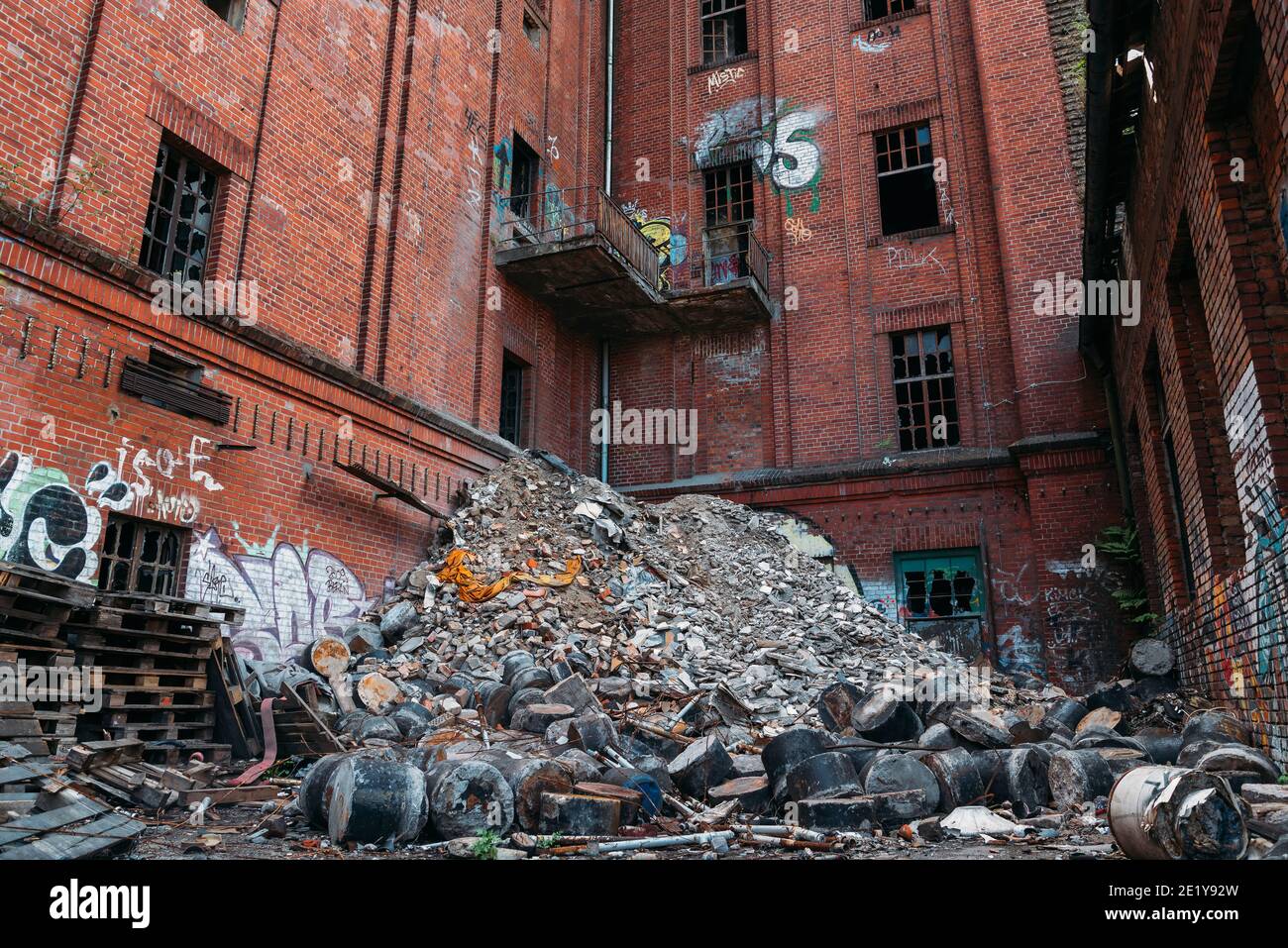 A large heap of rubble and bulky waste in front of a brick facade ...