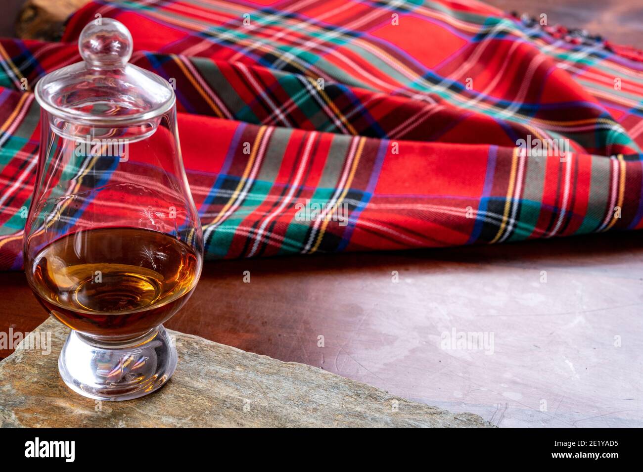 One dram of single malt scotch whisky with red scottish tartan on ...