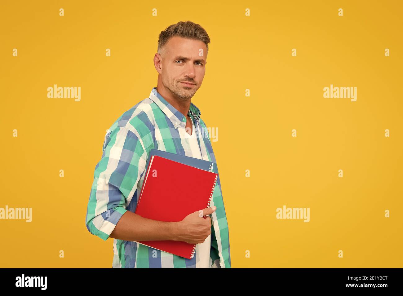 adult man student holding notebooks. man with folder yellow background ...