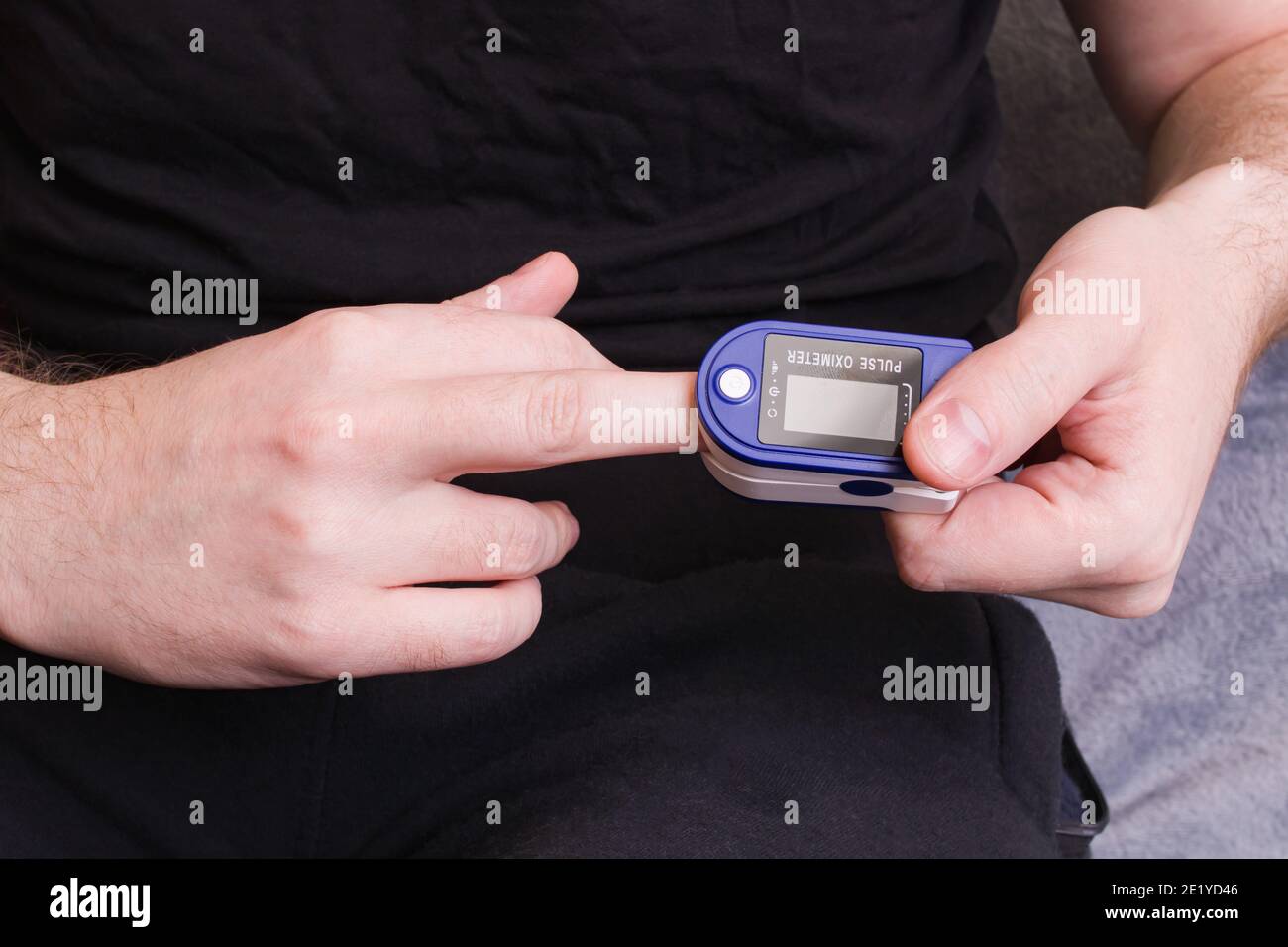 Hand puts a pulse oximeter on the middle finger Stock Photo - Alamy