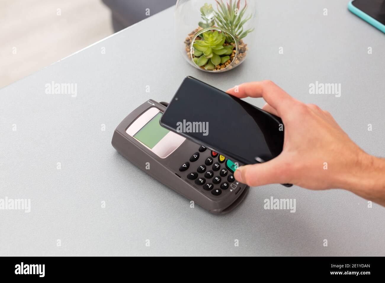 Customer using mobile phone to pay by NFC Stock Photo - Alamy