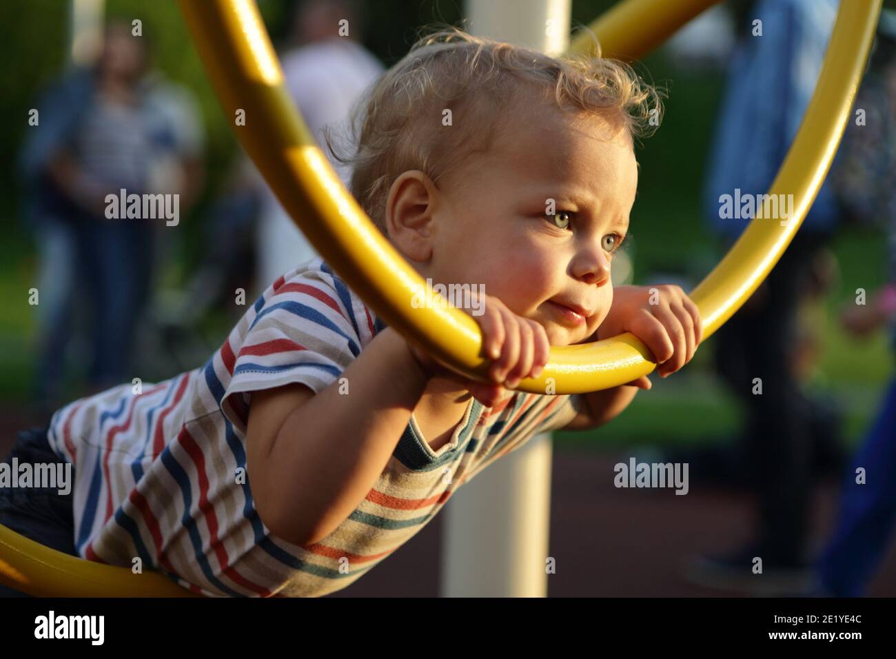 Child climbing ring obstacle at an outdoor playground Stock Photo - Alamy