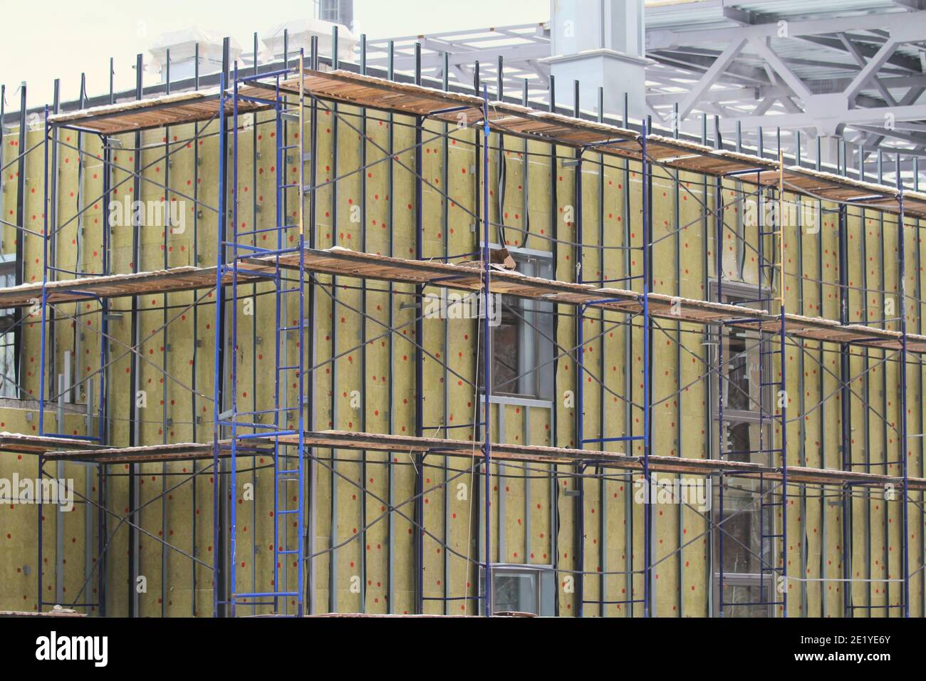 Scaffolding near the concrete wall of a building under construction ...