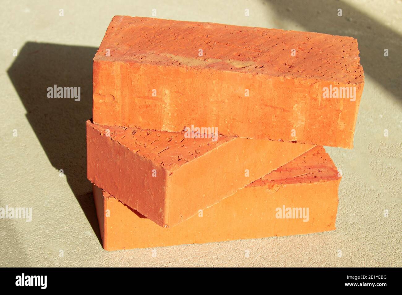 Three red bricks on the floor in sunlight Stock Photo - Alamy
