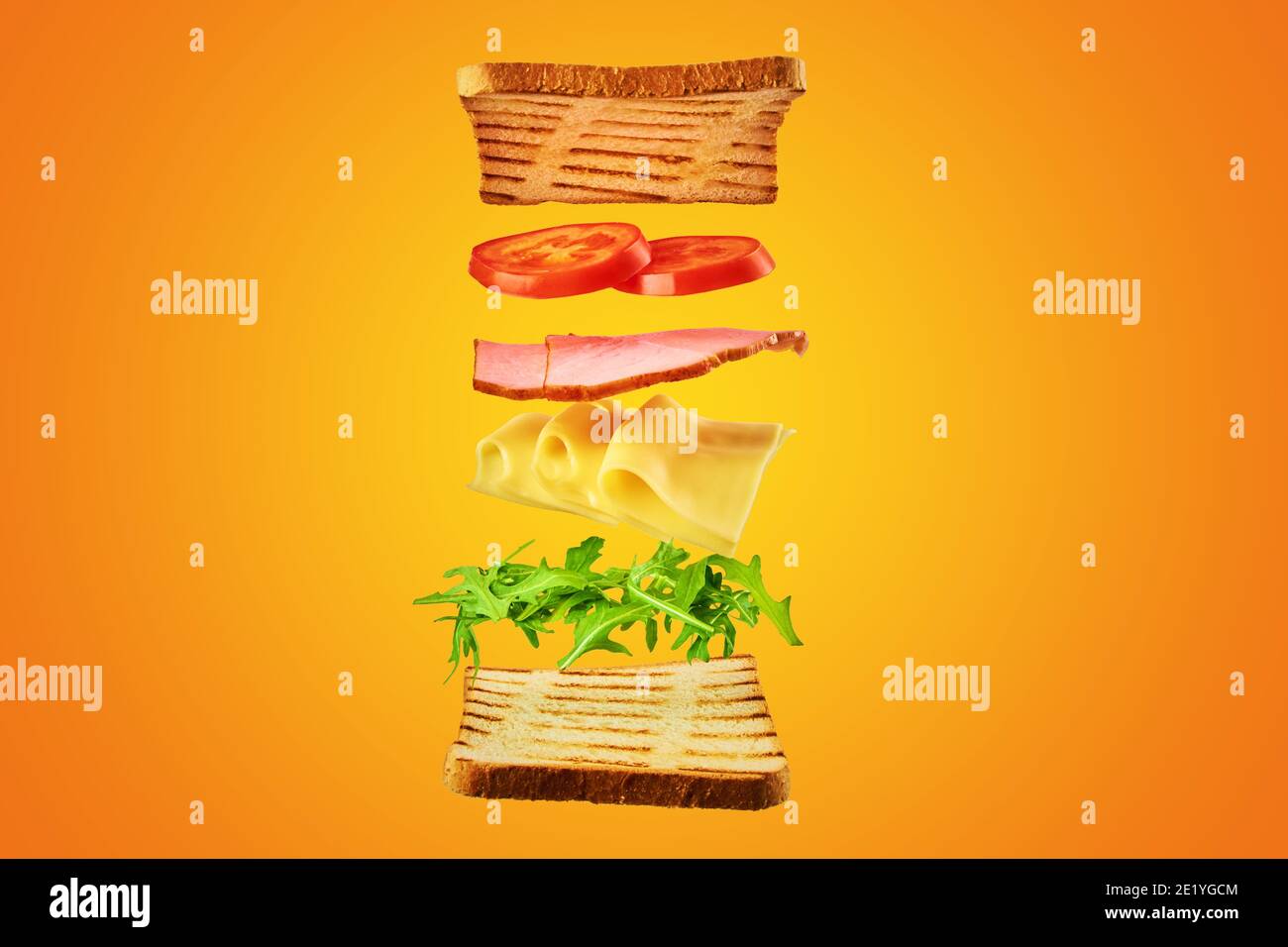 Fresh sandwich with flying ingredients on the yellow background ...