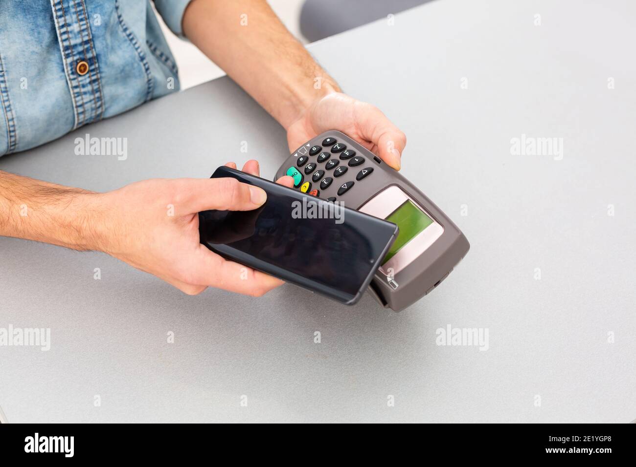 Customer using mobile phone to pay by NFC Stock Photo - Alamy