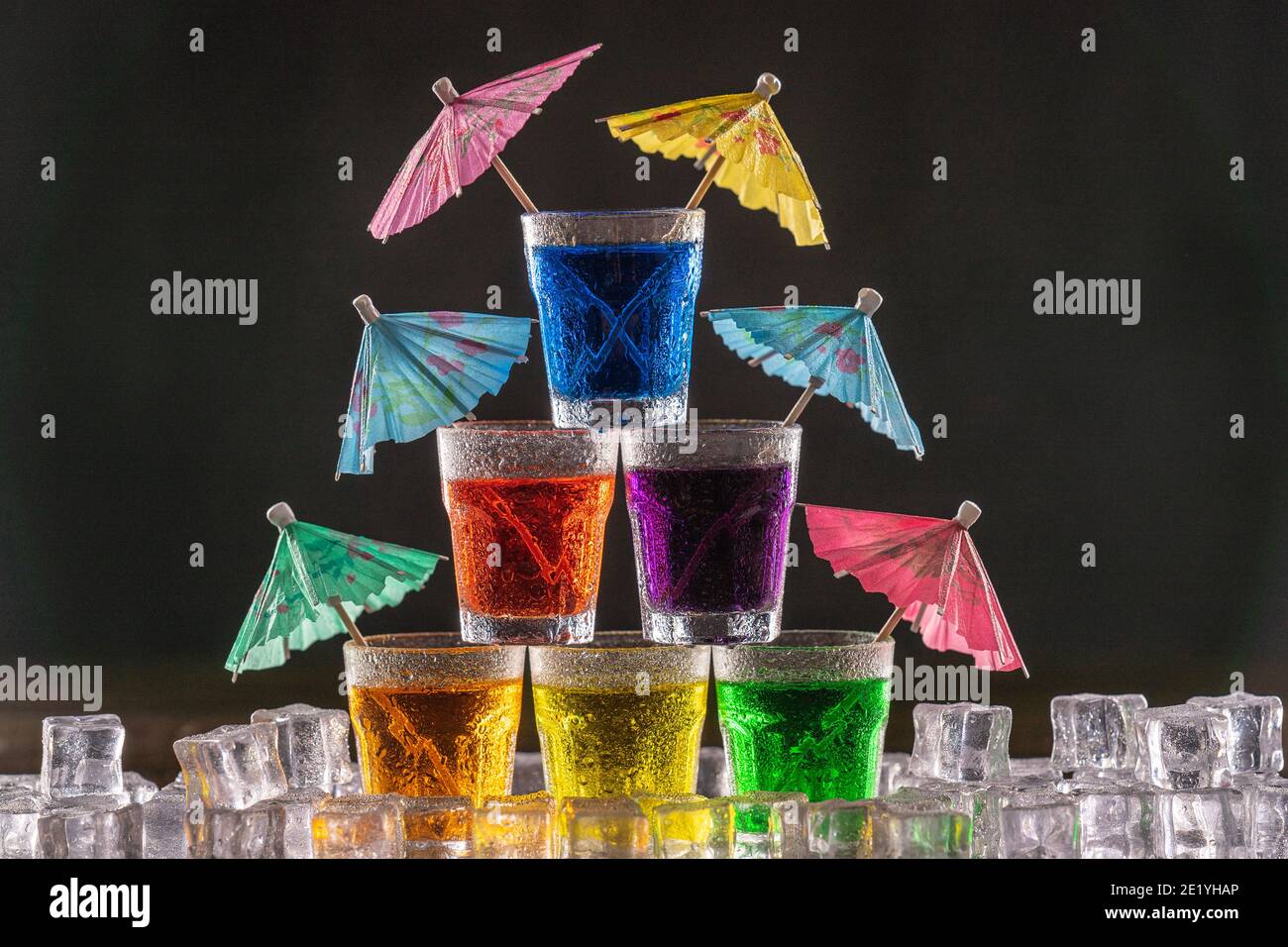 Pyramid of shots with colorful alcohol, decorated with umbrellas for ...