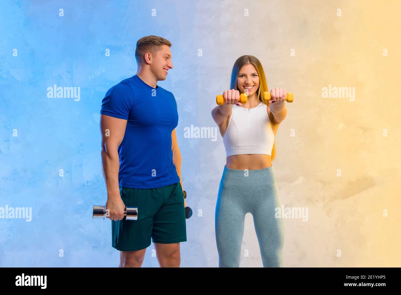 Attractive young couple in sport wear doing exercise in the gym ...