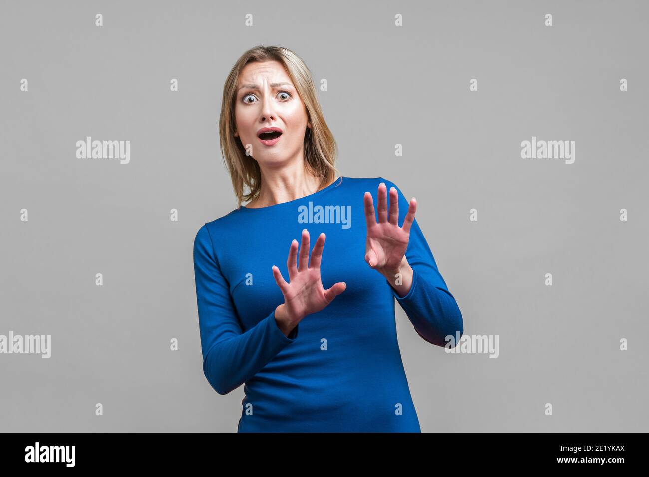I'm afraid! Portrait of panicked scared woman in tight blue dress ...