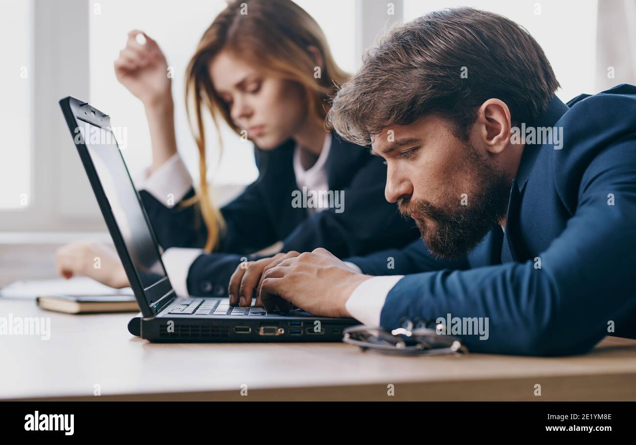 tired man and woman at work colleagues at work laptop professionals ...