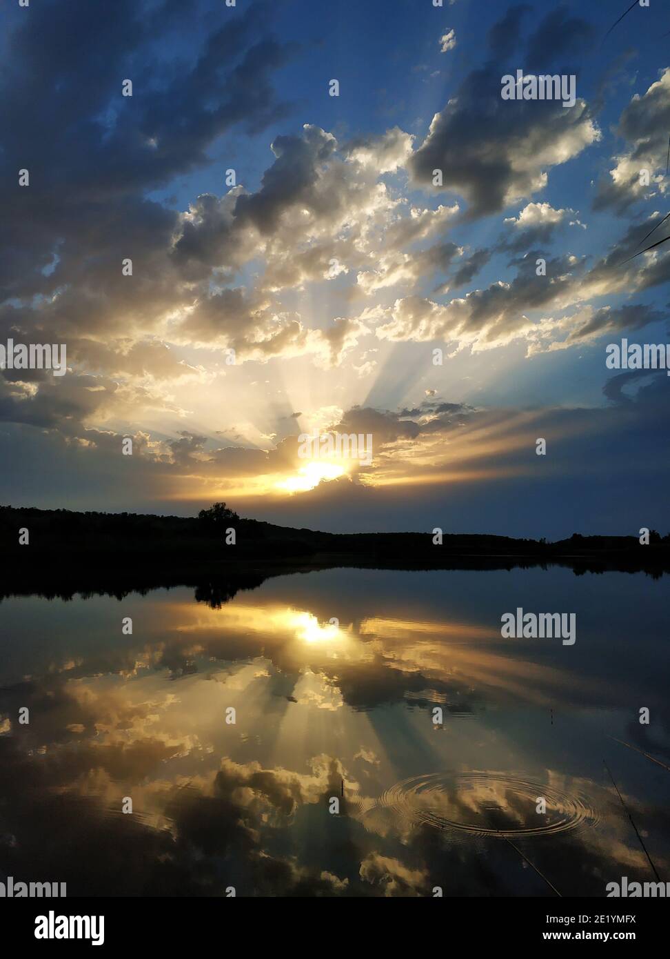 Natural landscape. Sunset over water, reflection of the sun and clouds ...