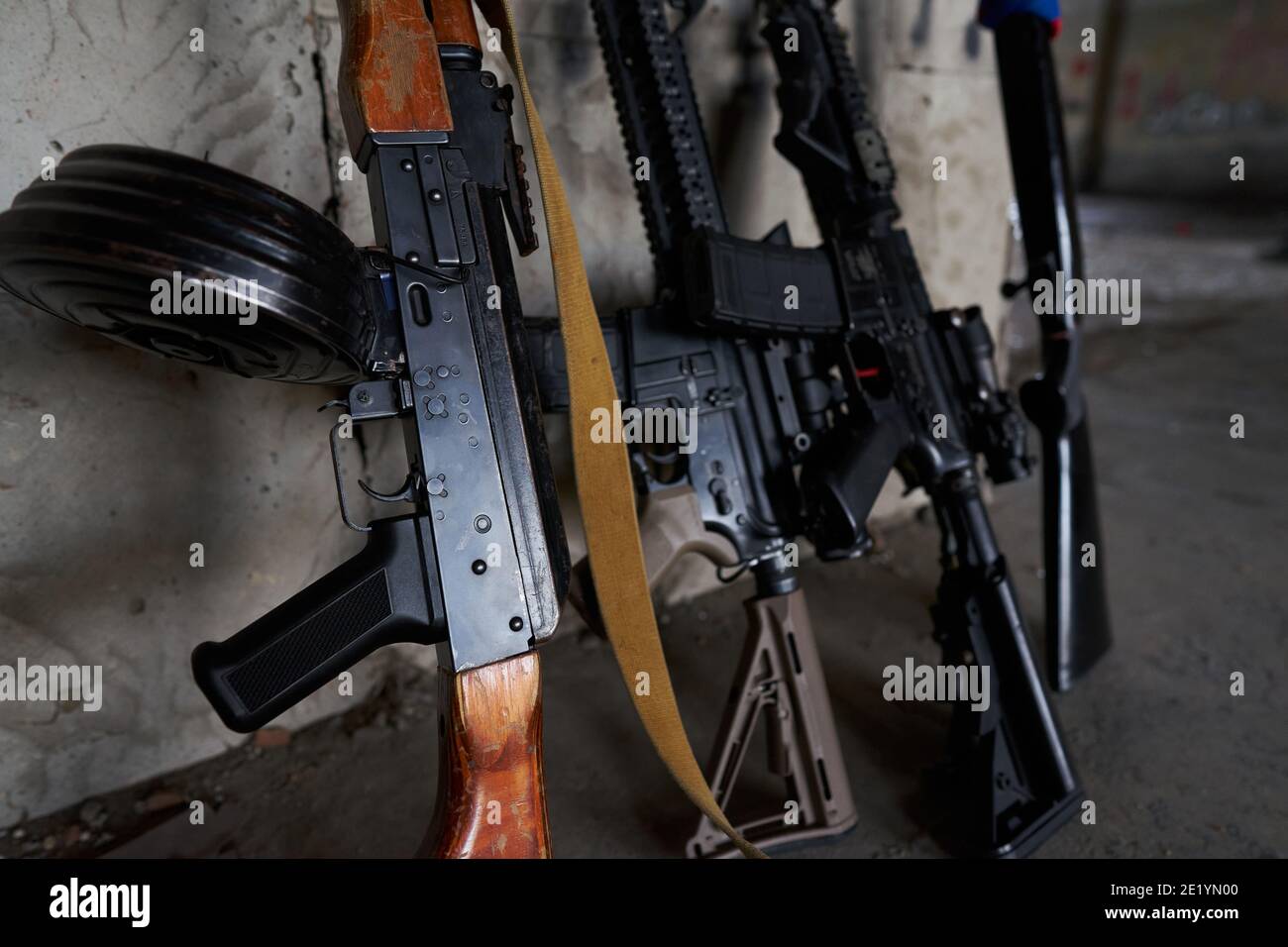 Machine gun, rifle, shotgun are leaning against the wall of the house ...
